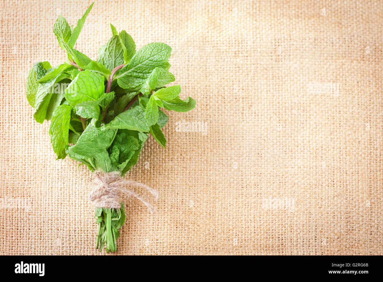 Fresh mint bunch on a burlap background Stock Photo - Alamy