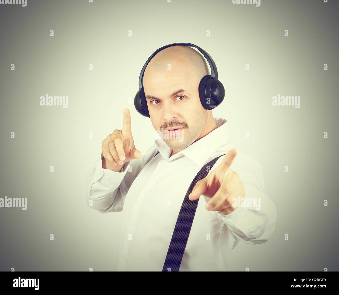 bald man with a mustache businessman listening to music on headphones ...