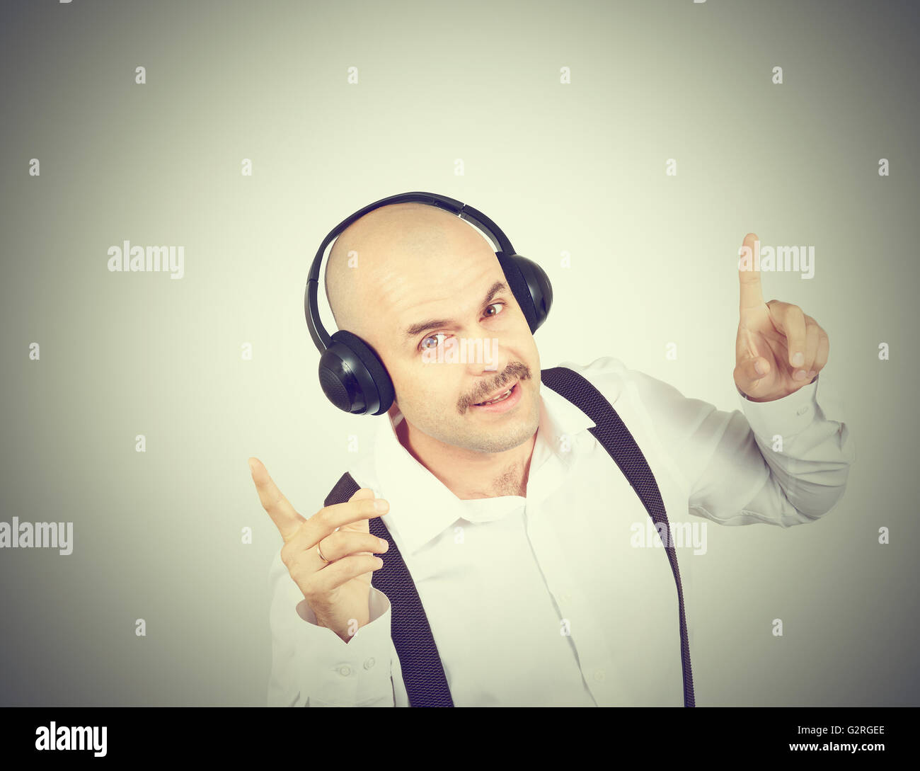 bald man with a mustache businessman listening to music on headphones ...