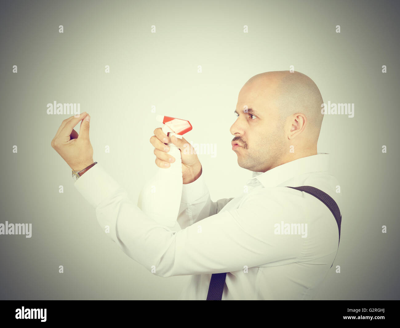 bald male cleaning worker spraying liquid detergent in front of him ...