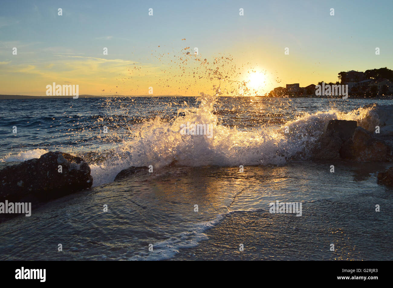 Breaking waves at sunset Stock Photo - Alamy