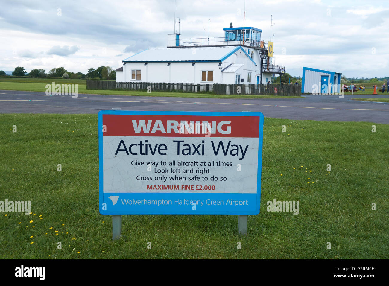 Active Taxiway warning sign with aircraft and control tower in ...