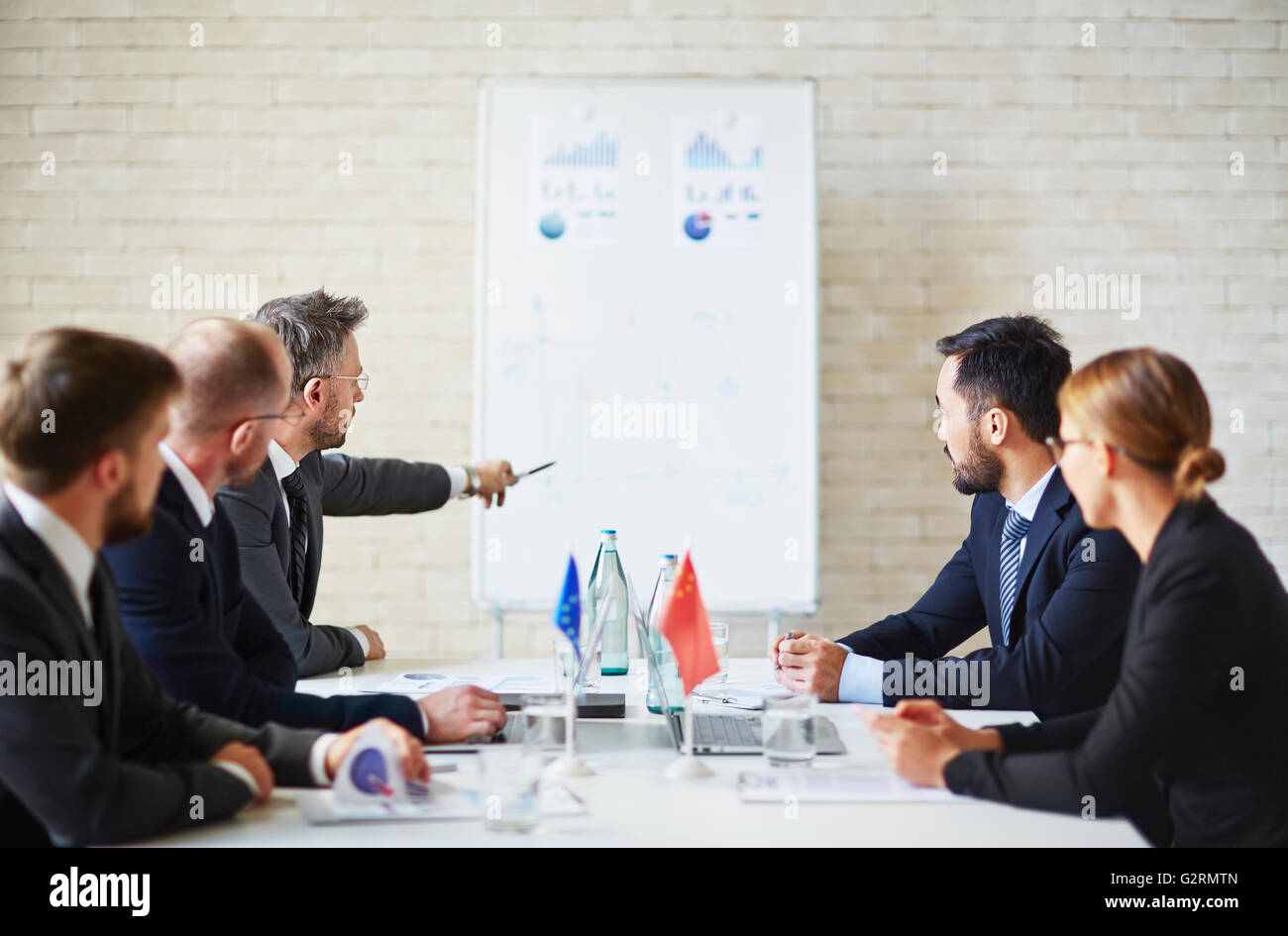 Successful leader explaining data to colleagues at briefing Stock Photo ...