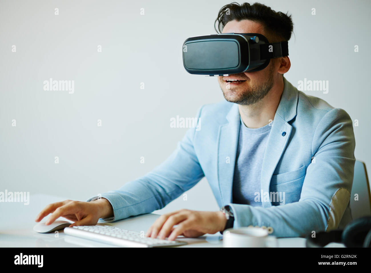 Happy manager typing on keypad while networking in vr Stock Photo - Alamy