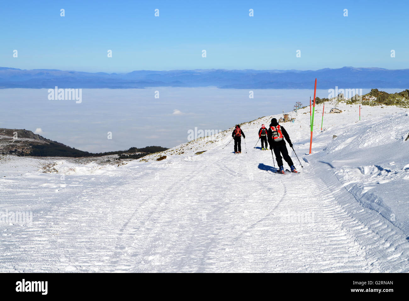 Three skiers descend from the peak Stock Photo - Alamy