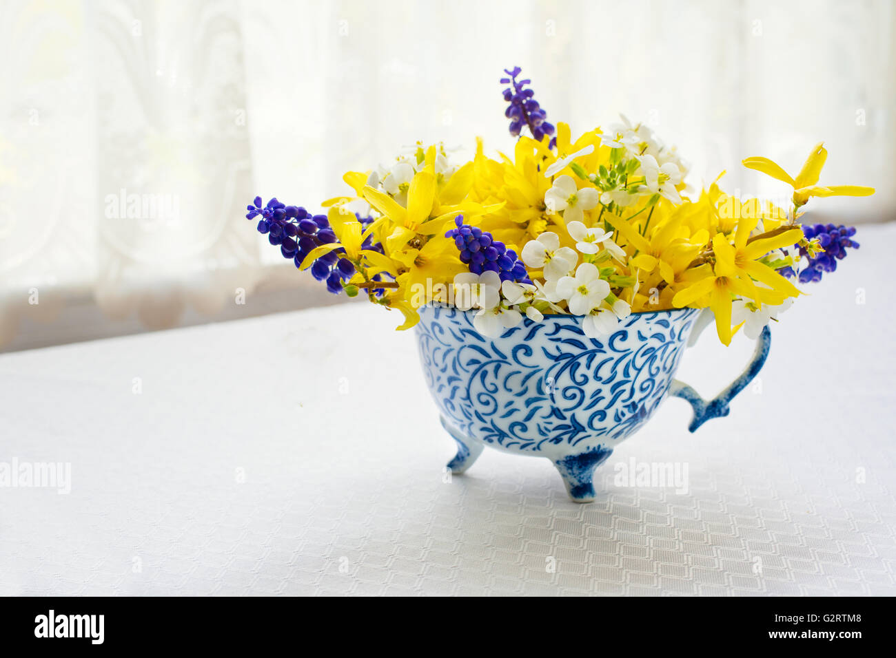 Teacup full of a spring flower bouquet Stock Photo - Alamy