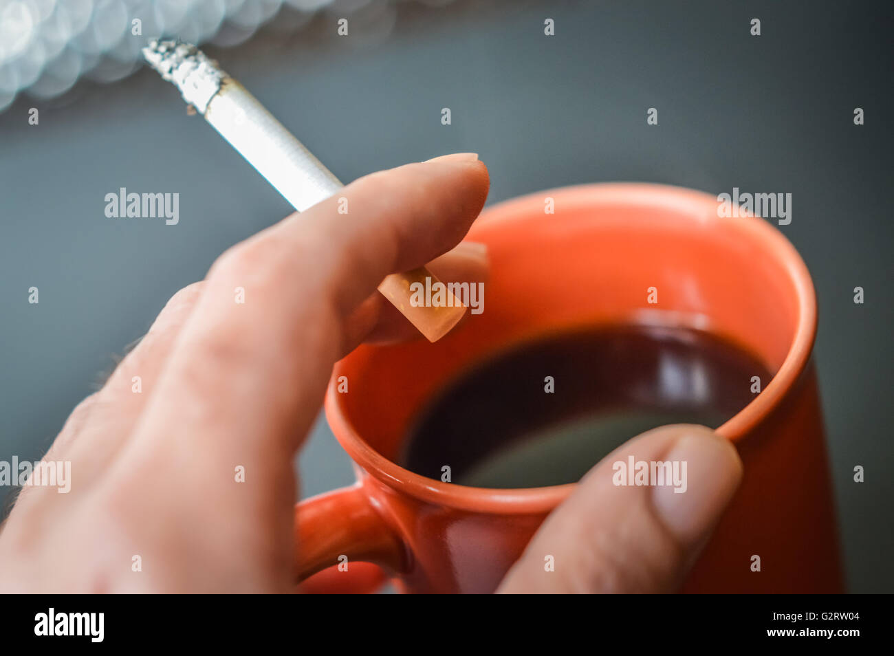 hand holding a cigarette on a mug of coffee, unhealthy habits Stock ...