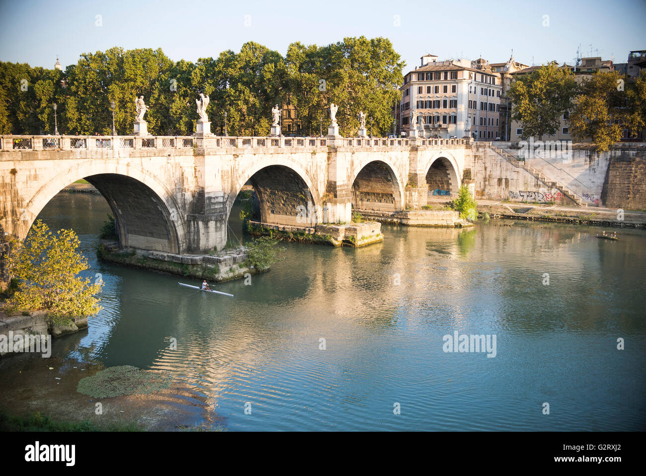 A man in a Kayak paddling through the Tiber River and below the Ponte ...