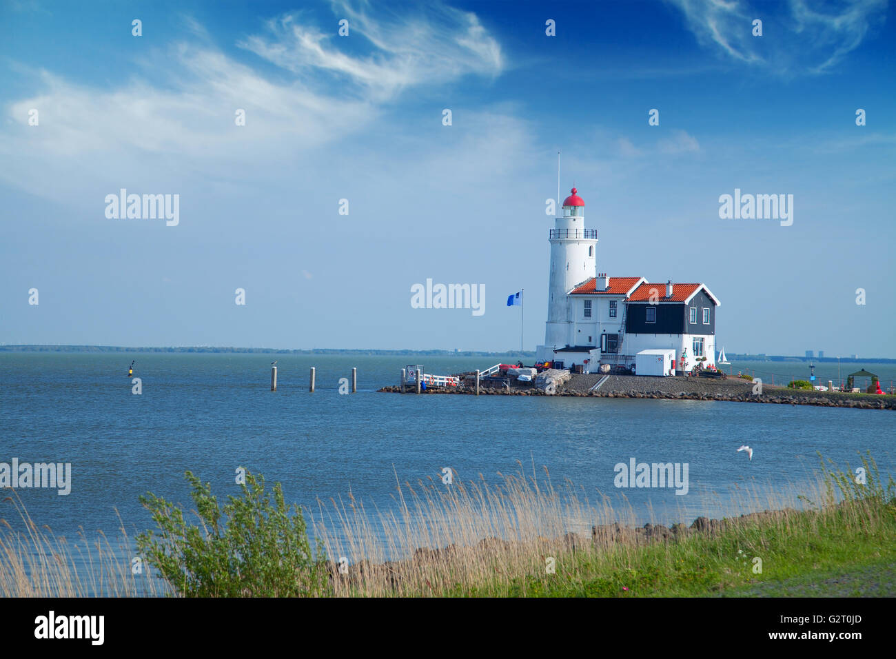 lonely lighthouse stands on the spit in the sea near the village of ...