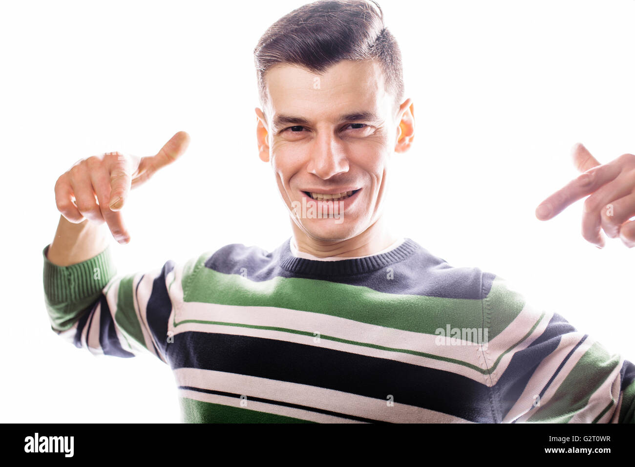 Portrait of a smart serious young man standing against white background ...