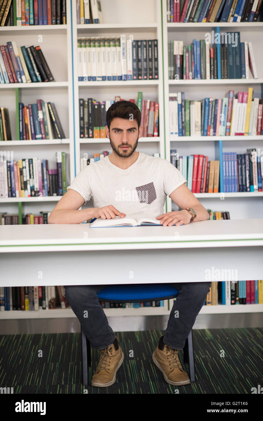 Student reading book in school library. Study lessons for exam. Hard ...