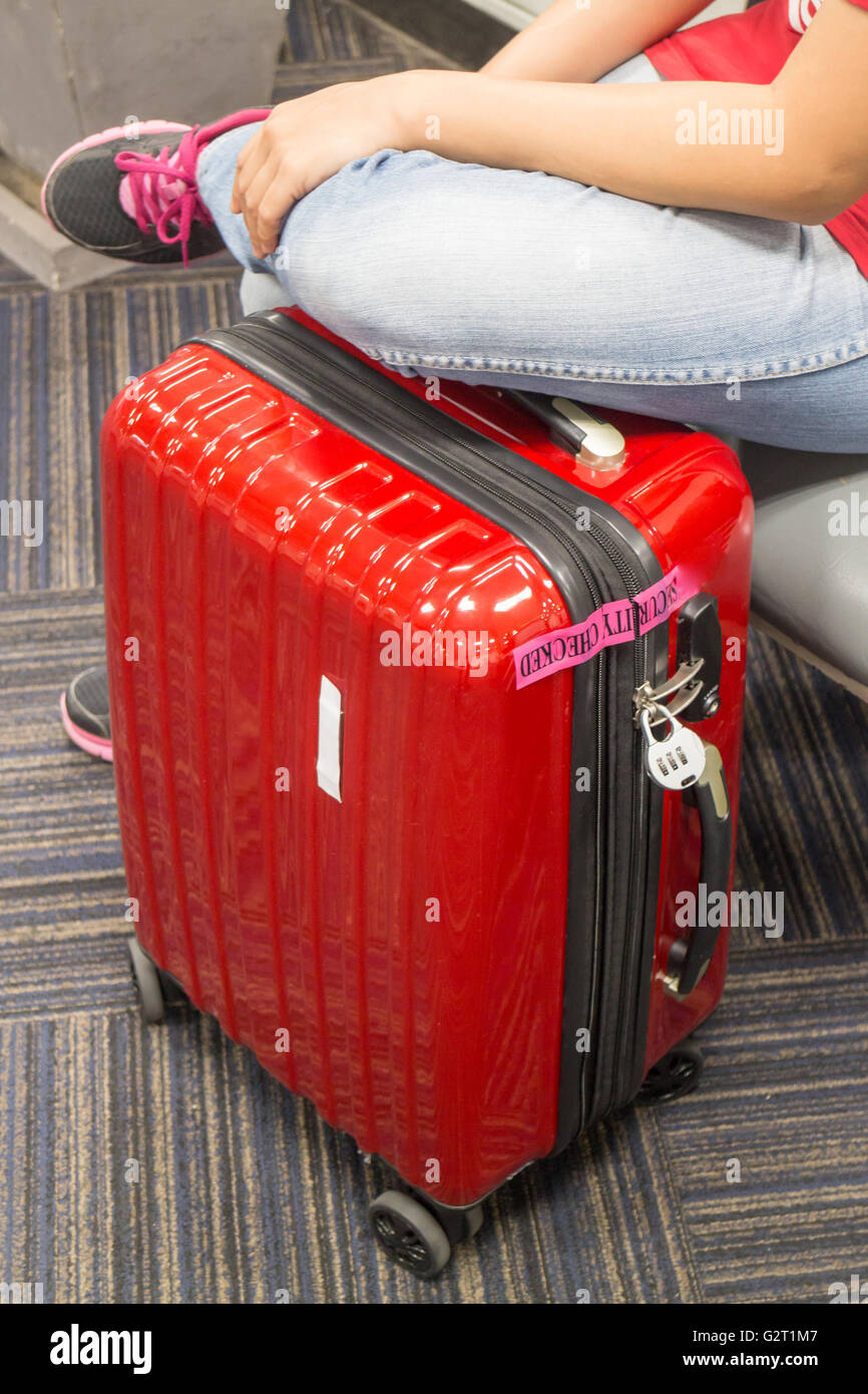 Passenger sitting and red traveling suitcase hi-res stock photography ...