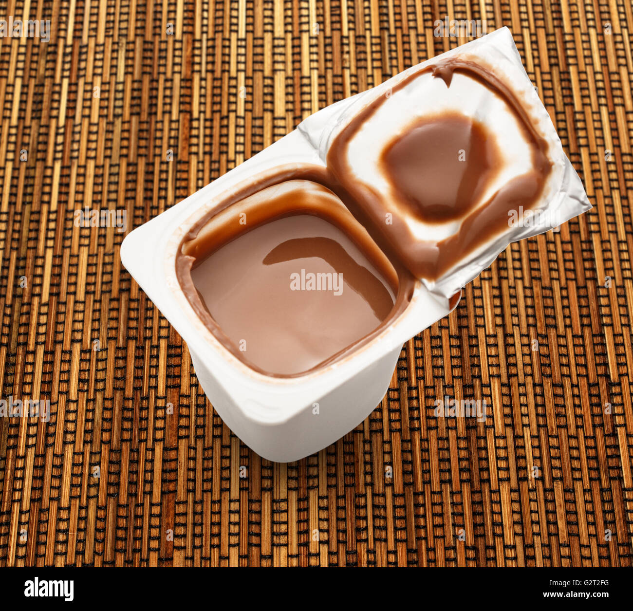 Open yogurt in pot on wooden background in closeup Stock Photo - Alamy