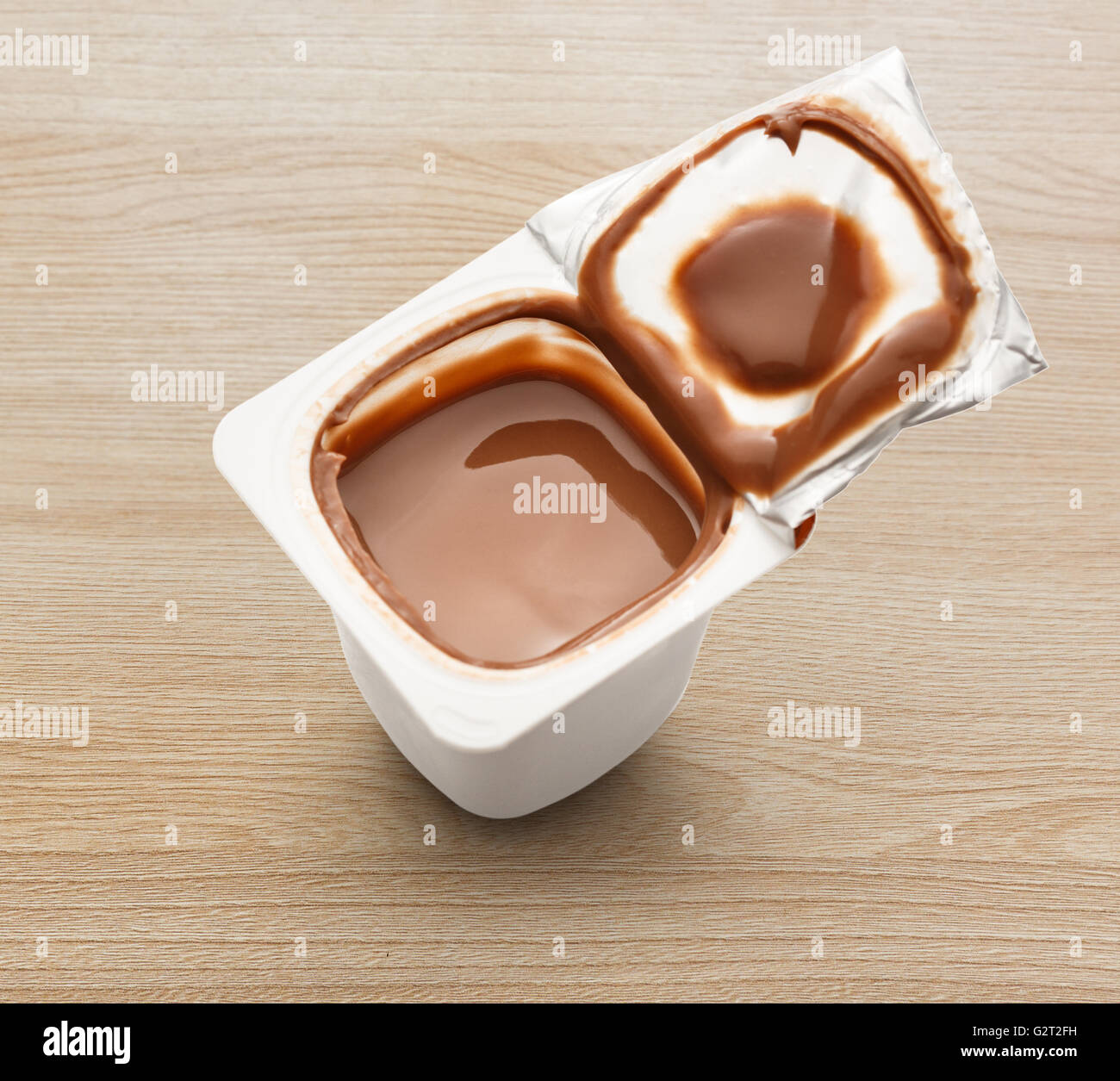 Open yogurt in pot on wooden background in closeup Stock Photo - Alamy
