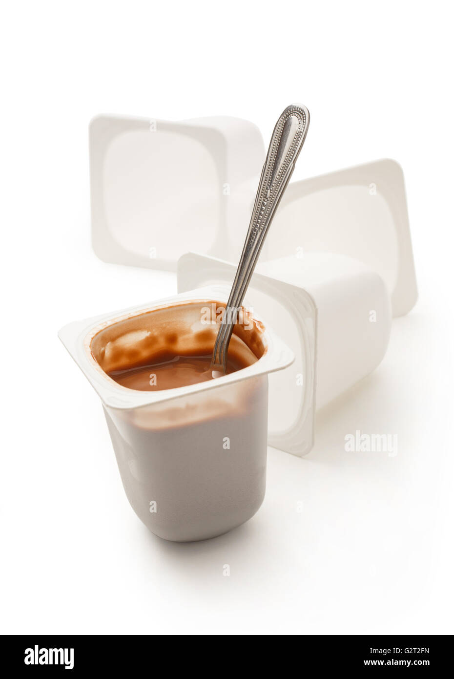 Open yogurt in pot with metal spoon and empty plastic yogurt pots Stock ...