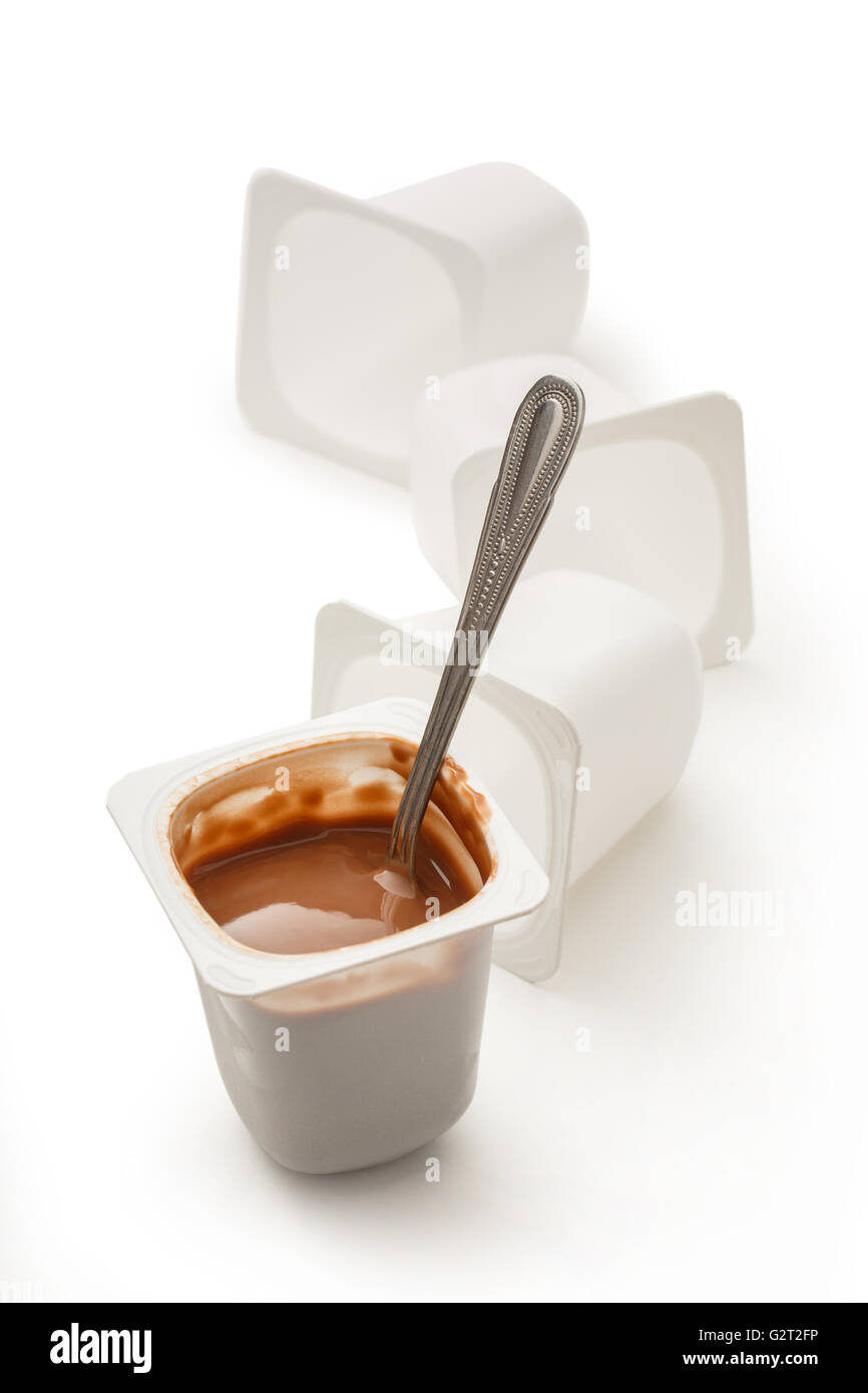 Open yogurt in pot with metal spoon and empty plastic yogurt pots Stock ...