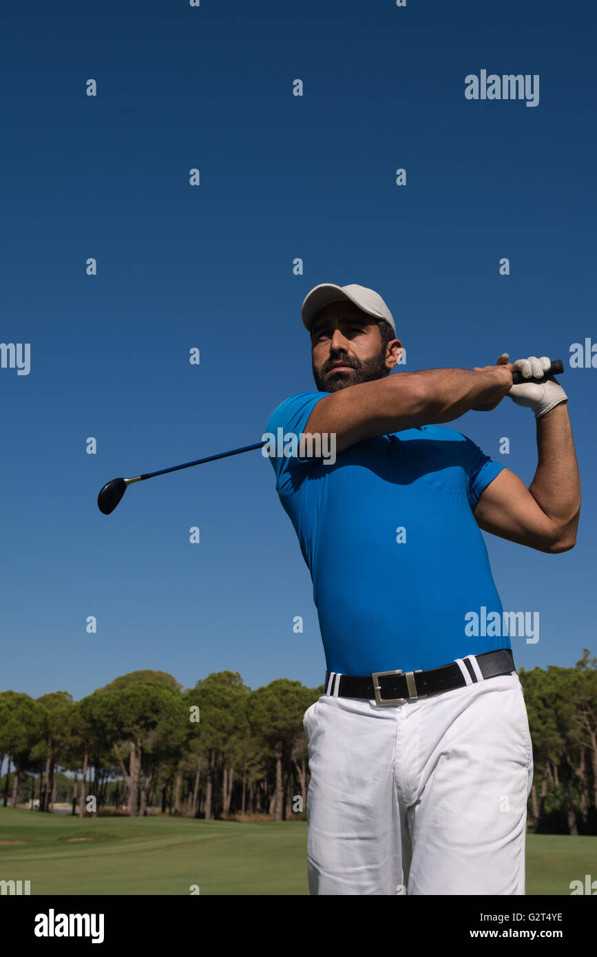 golf player hitting shot with club on course at beautiful morning with ...