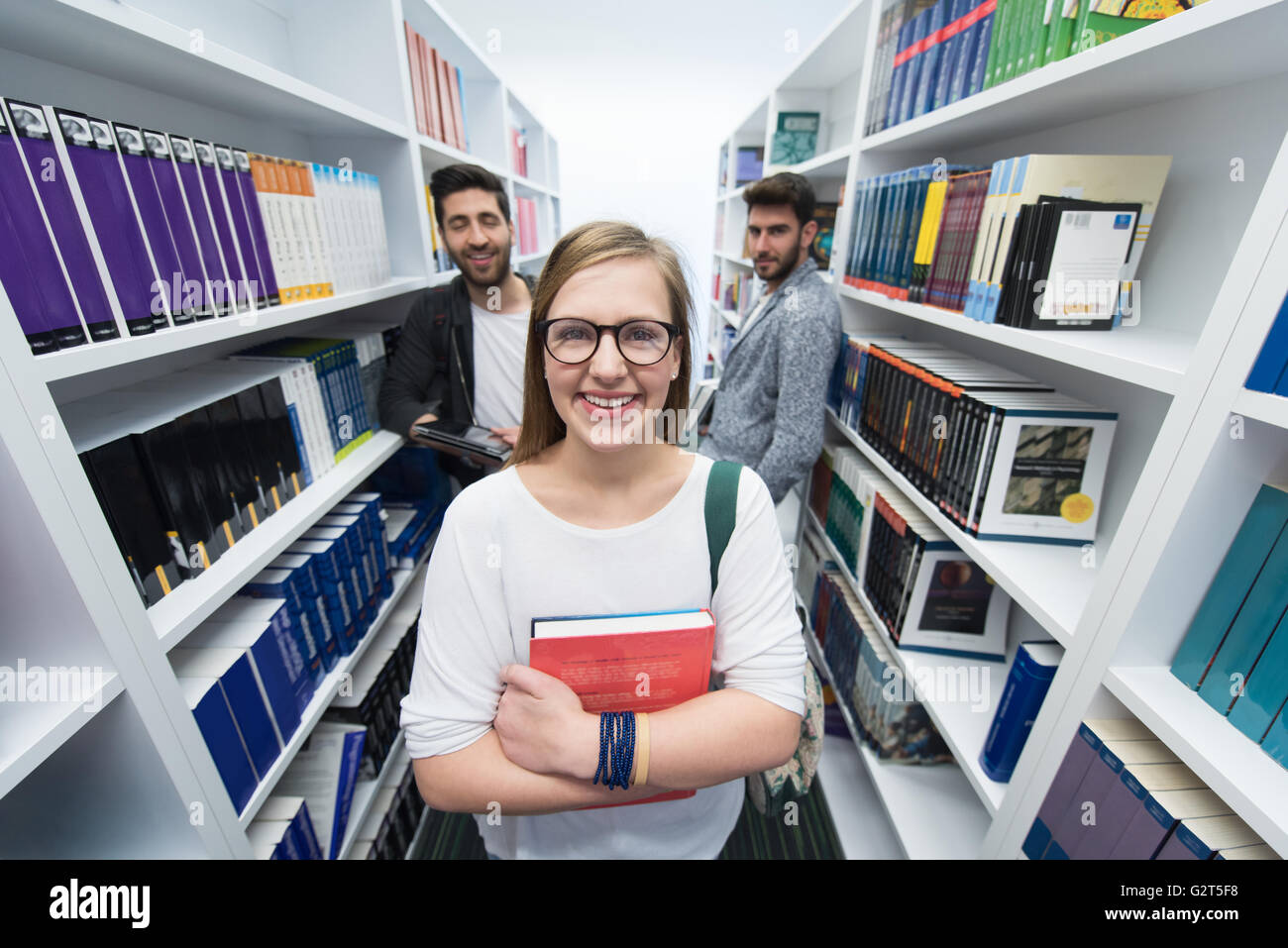 happy students group in school library selecting books to read and ...