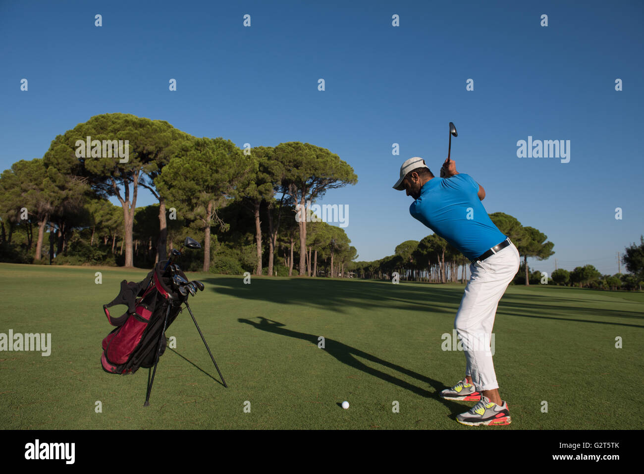 golf player hitting shot with club on course at beautiful morning with ...