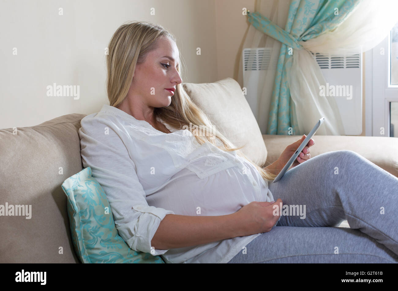 pregnant woman spends time with the tablet Stock Photo - Alamy