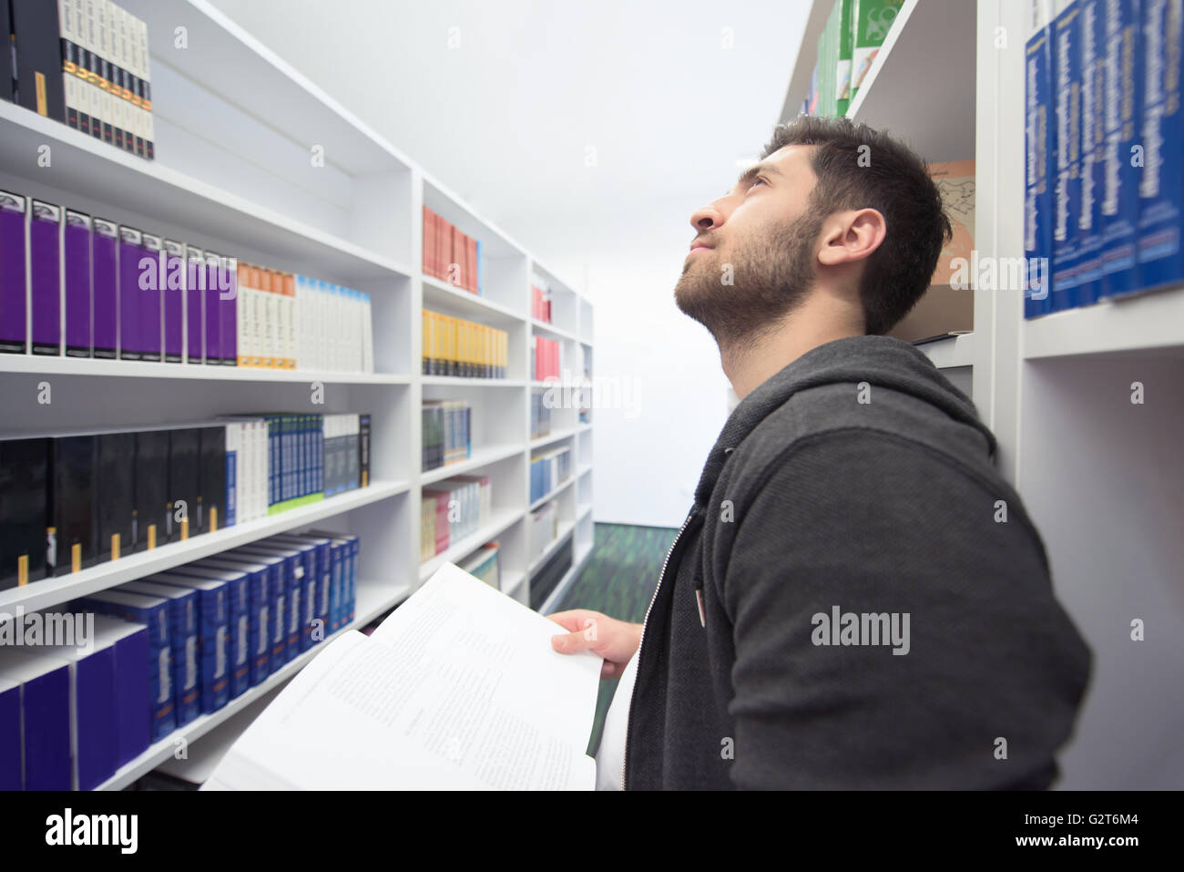 Student reading book in school library. Study lessons for exam. Hard ...