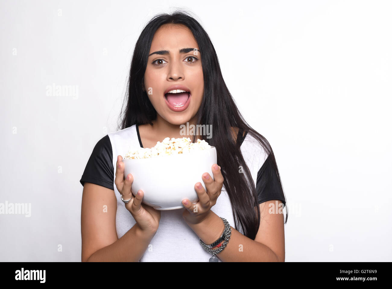 Young beautiful woman eating popcorn. Isolated white background Stock ...