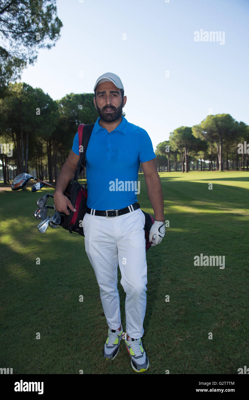 handsome middle eastern golf player carrying and bag and walking at ...