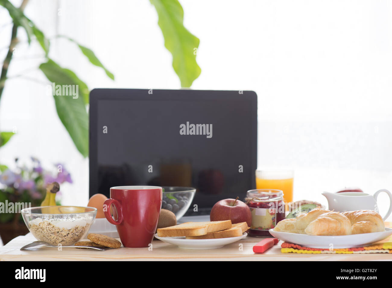 Breakfast on bright sunny morning with laptop Stock Photo - Alamy
