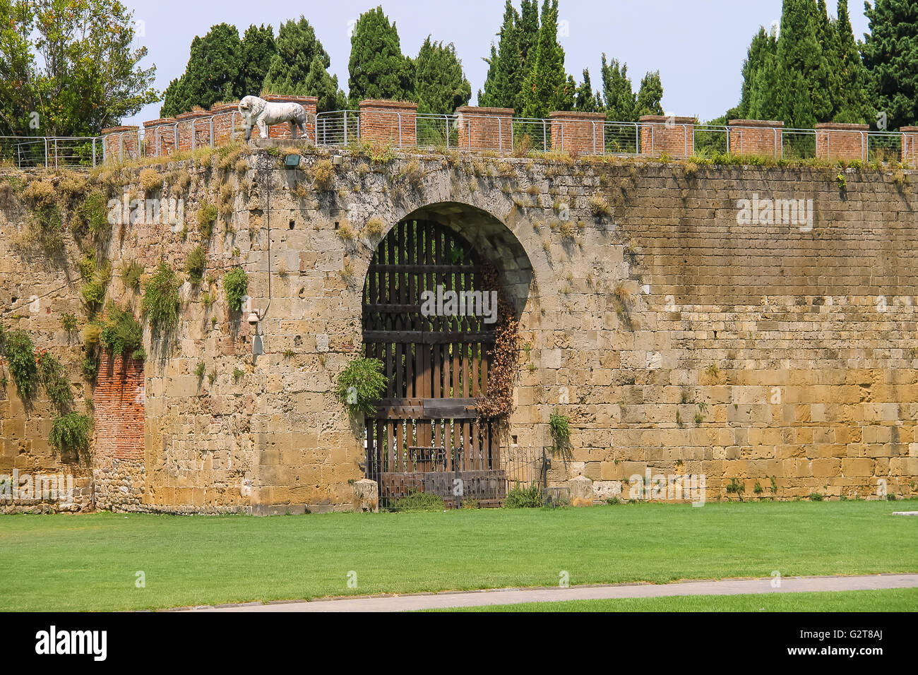 Antique fortified wall and gate with statue of lion. Pisa, Italy Stock ...