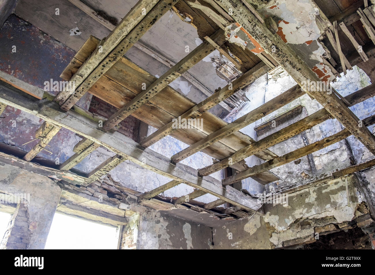 A derelict house with the upper floor and roof missing and plaster ...