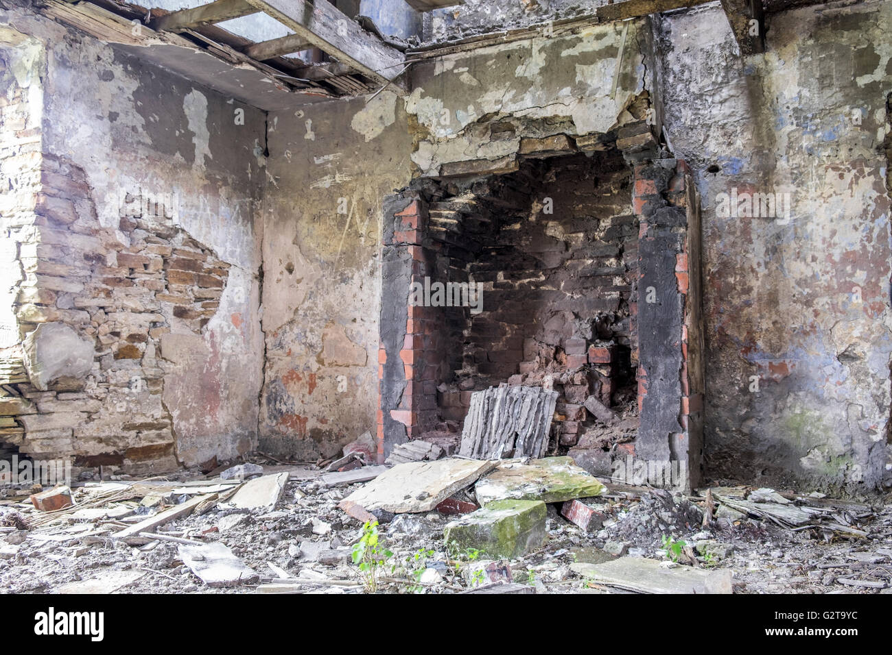 A derelict house with the upper floor and roof missing and plaster ...