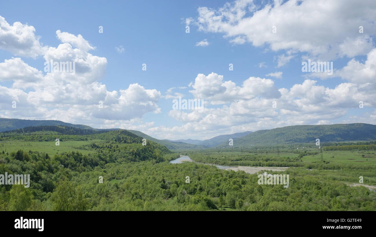 Wonderful landscape with green mountain forests and blue river in front ...