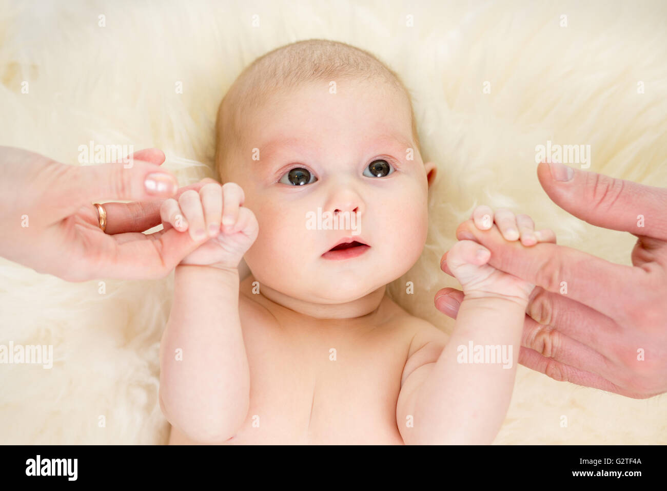 Parents holding baby infant hands. Top view Stock Photo - Alamy