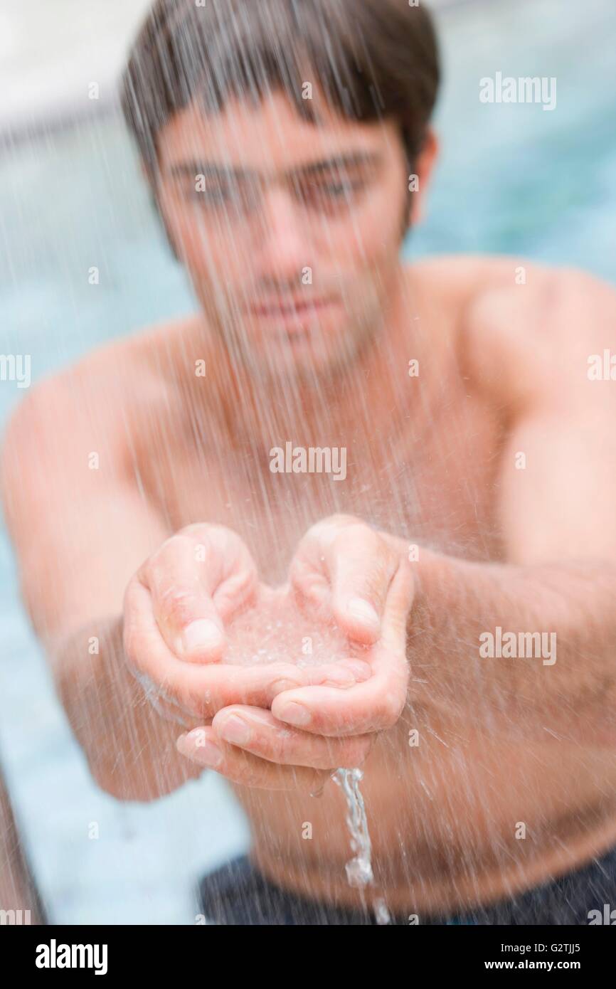 Young man standing under shower Stock Photo - Alamy