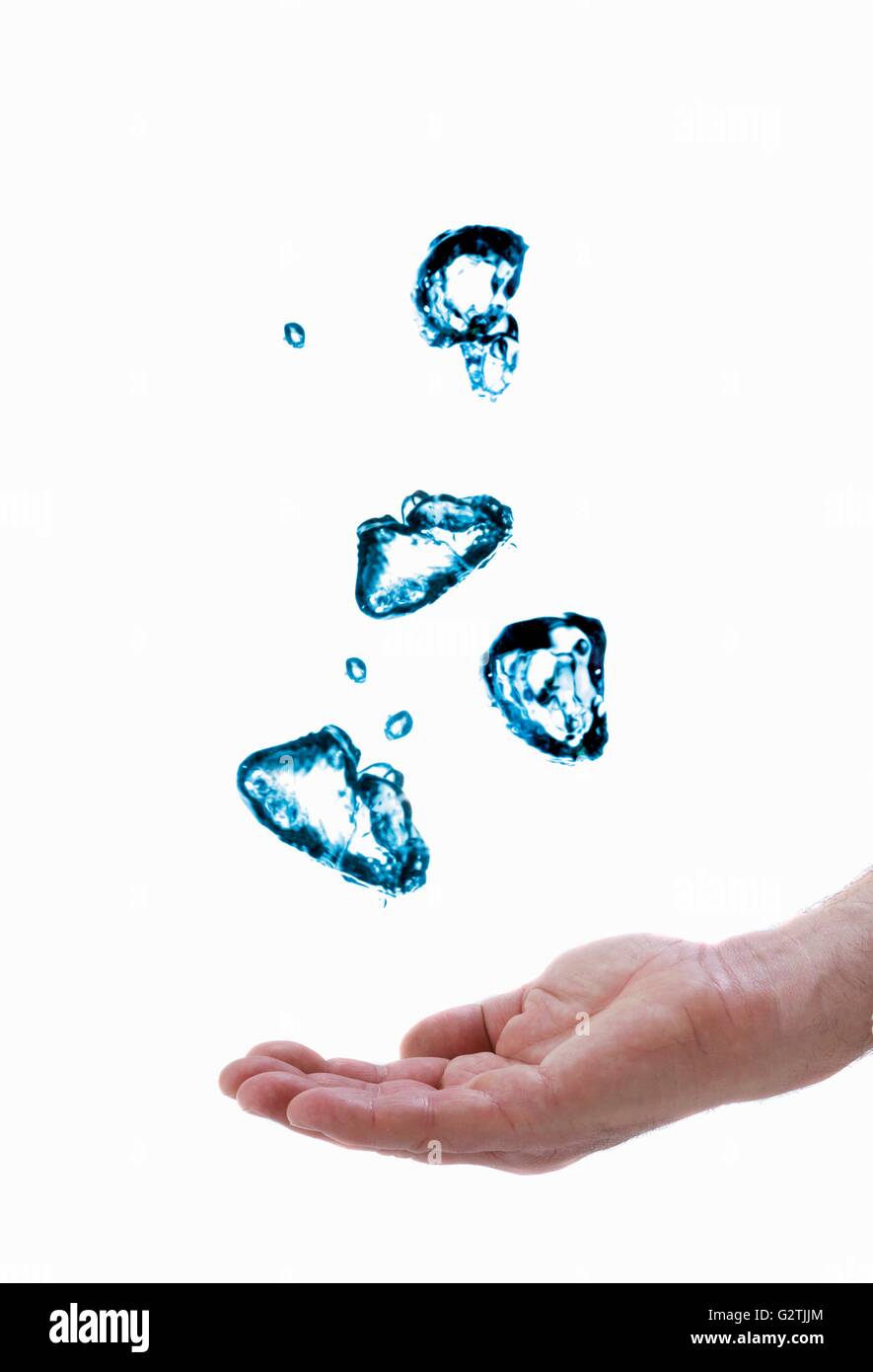 Hand catching ice cubes Stock Photo - Alamy