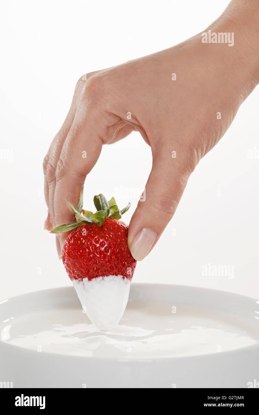 Hand dipped strawberries in organic yogurt Stock Photo - Alamy