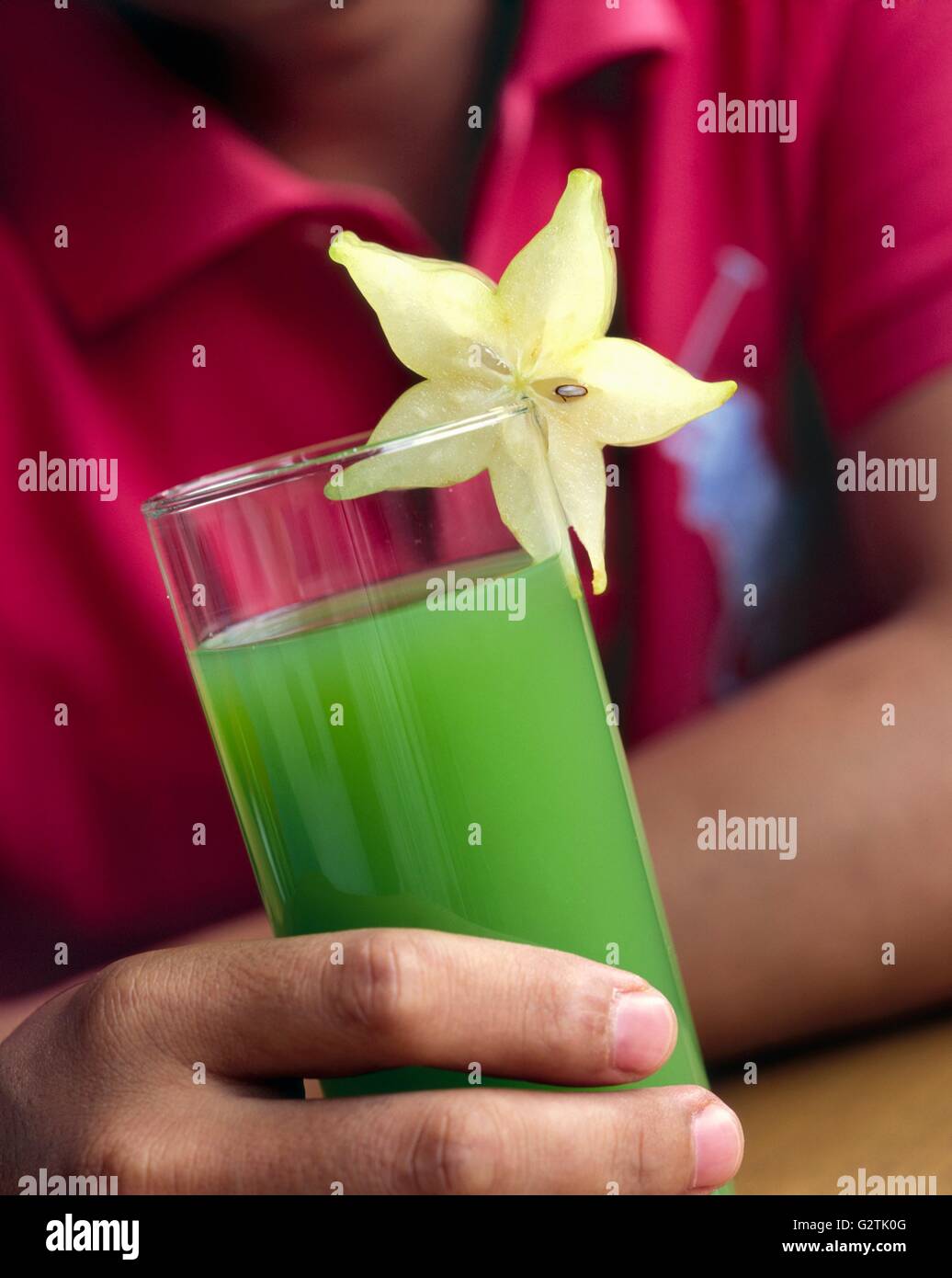 Young man holding kiwi fruit juice with starfruit garnish Stock Photo ...