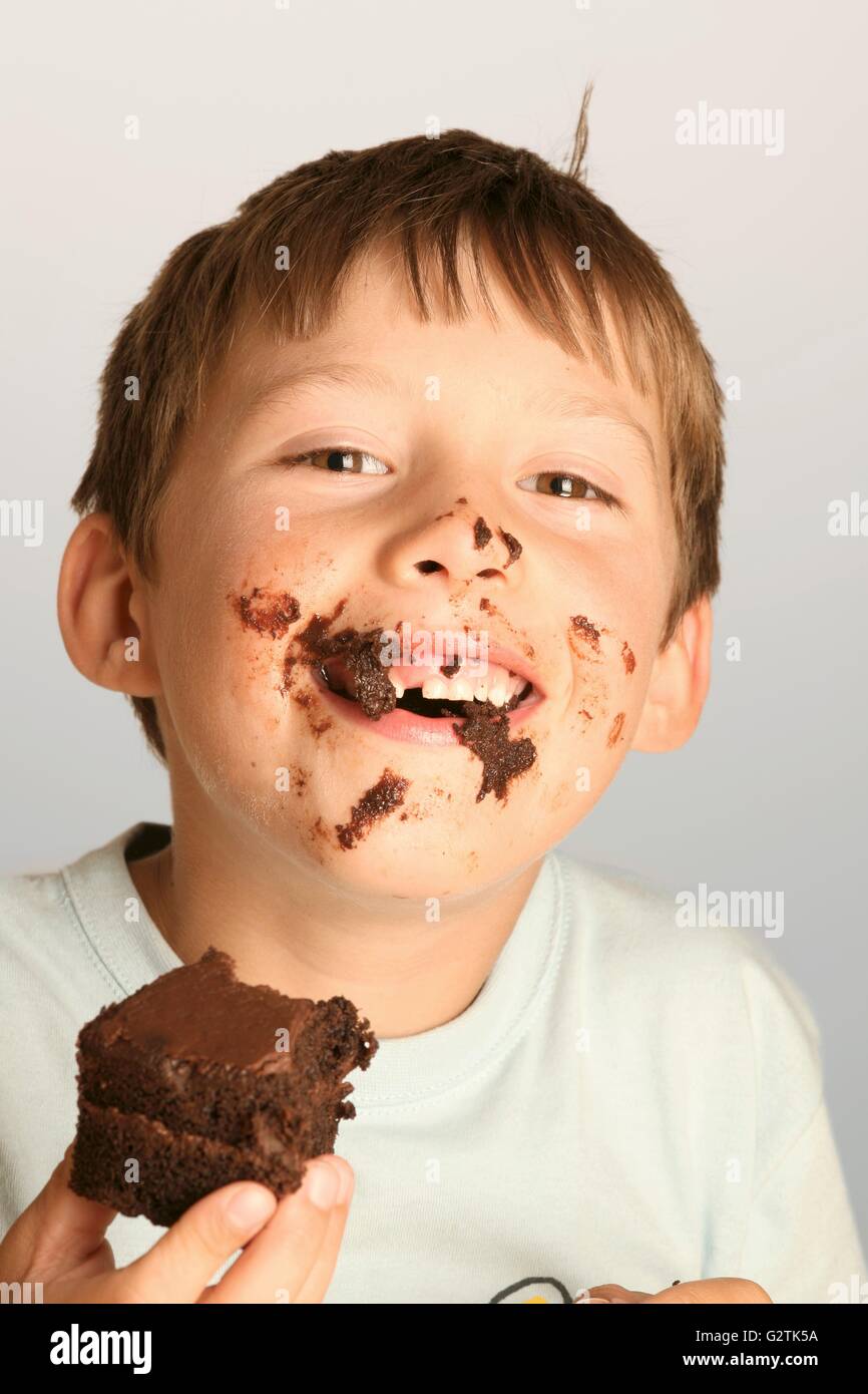 Boy eating a piece of chocolate cake Stock Photo - Alamy