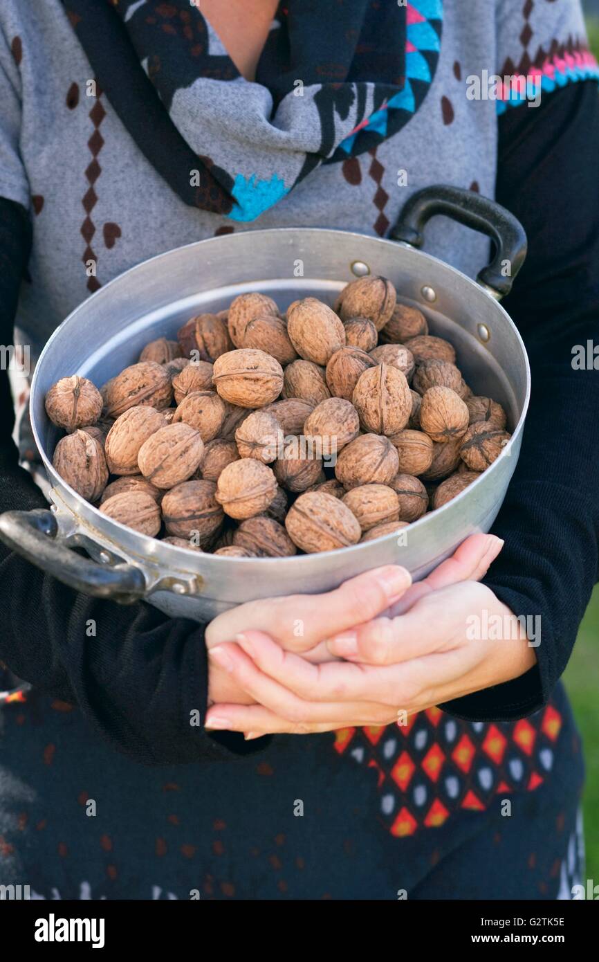 A woman holding a pot of walnuts Stock Photo - Alamy