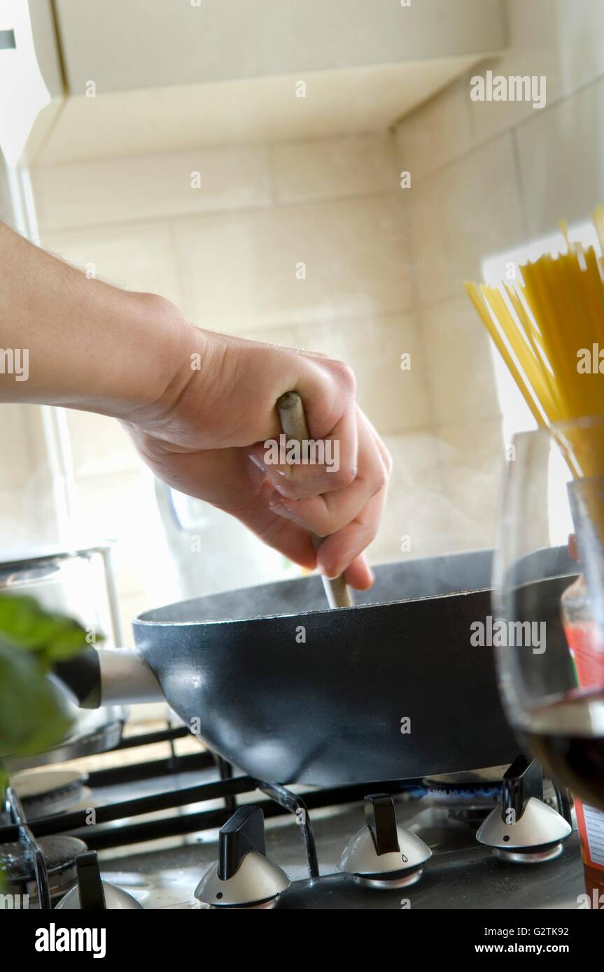 Turning ingredients in a frying pan Stock Photo - Alamy