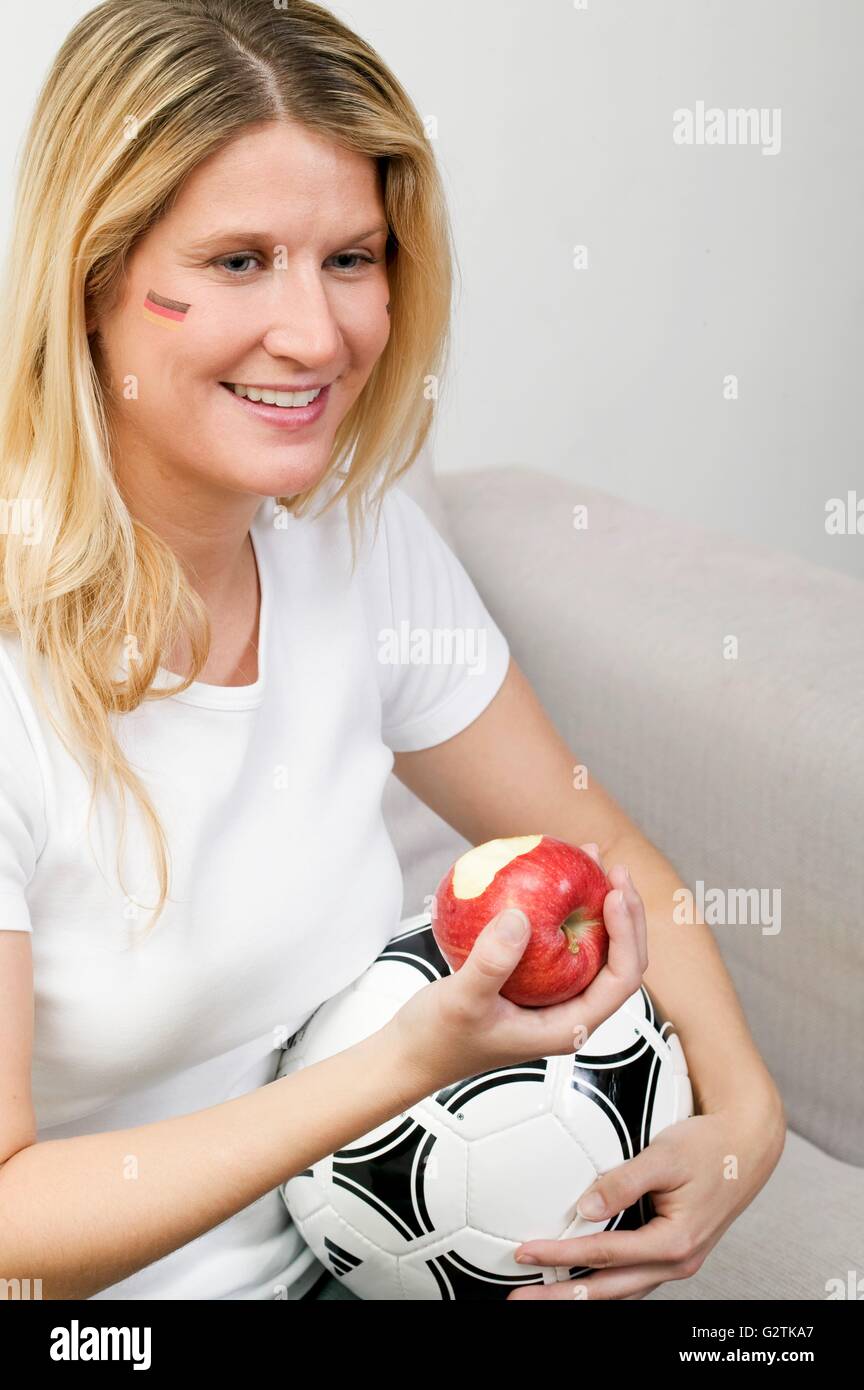 Young women with football eating an apple Stock Photo - Alamy