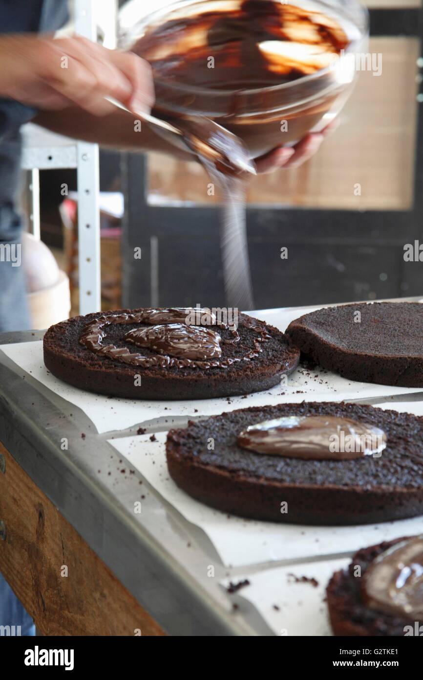 A chocolate cake being glazed Stock Photo - Alamy
