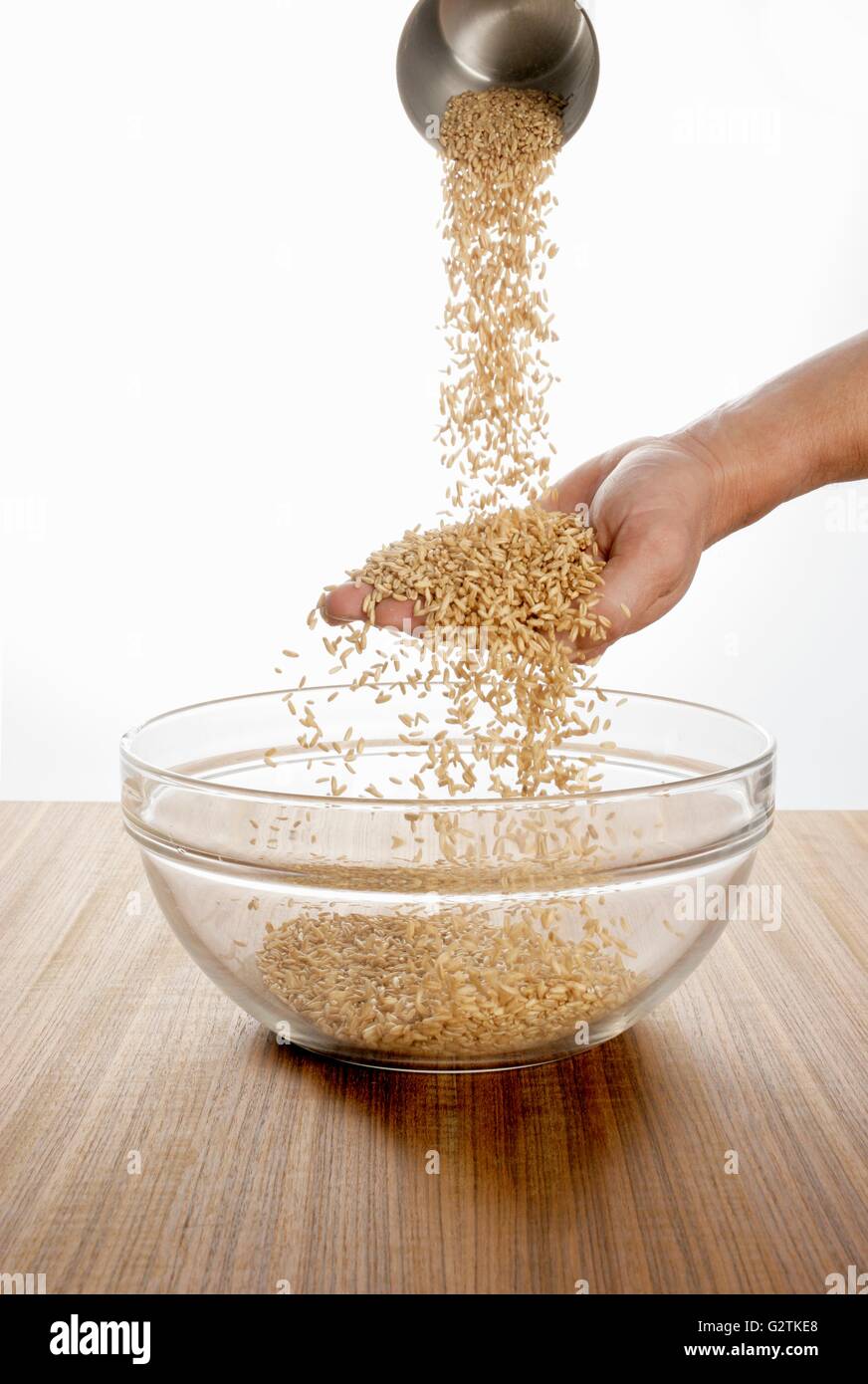 Someone pouring oats over their hand into a glass bowl Stock Photo - Alamy
