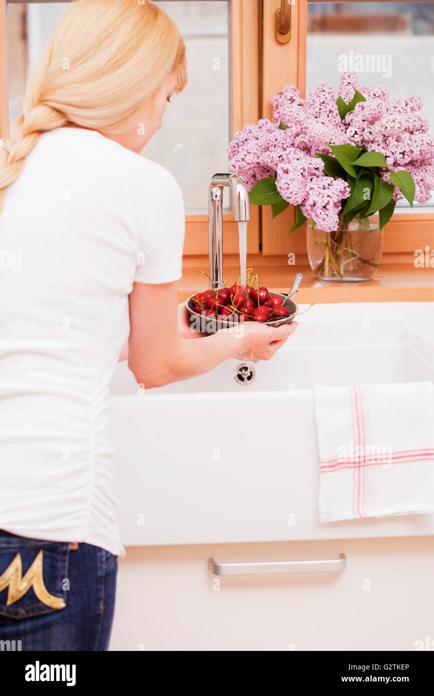 A woman washing cherries in a sink Stock Photo - Alamy