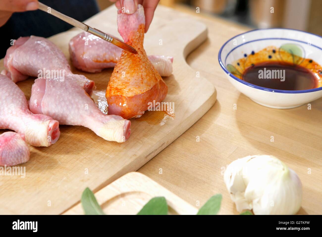 Brushing chicken thighs with marinade Stock Photo - Alamy