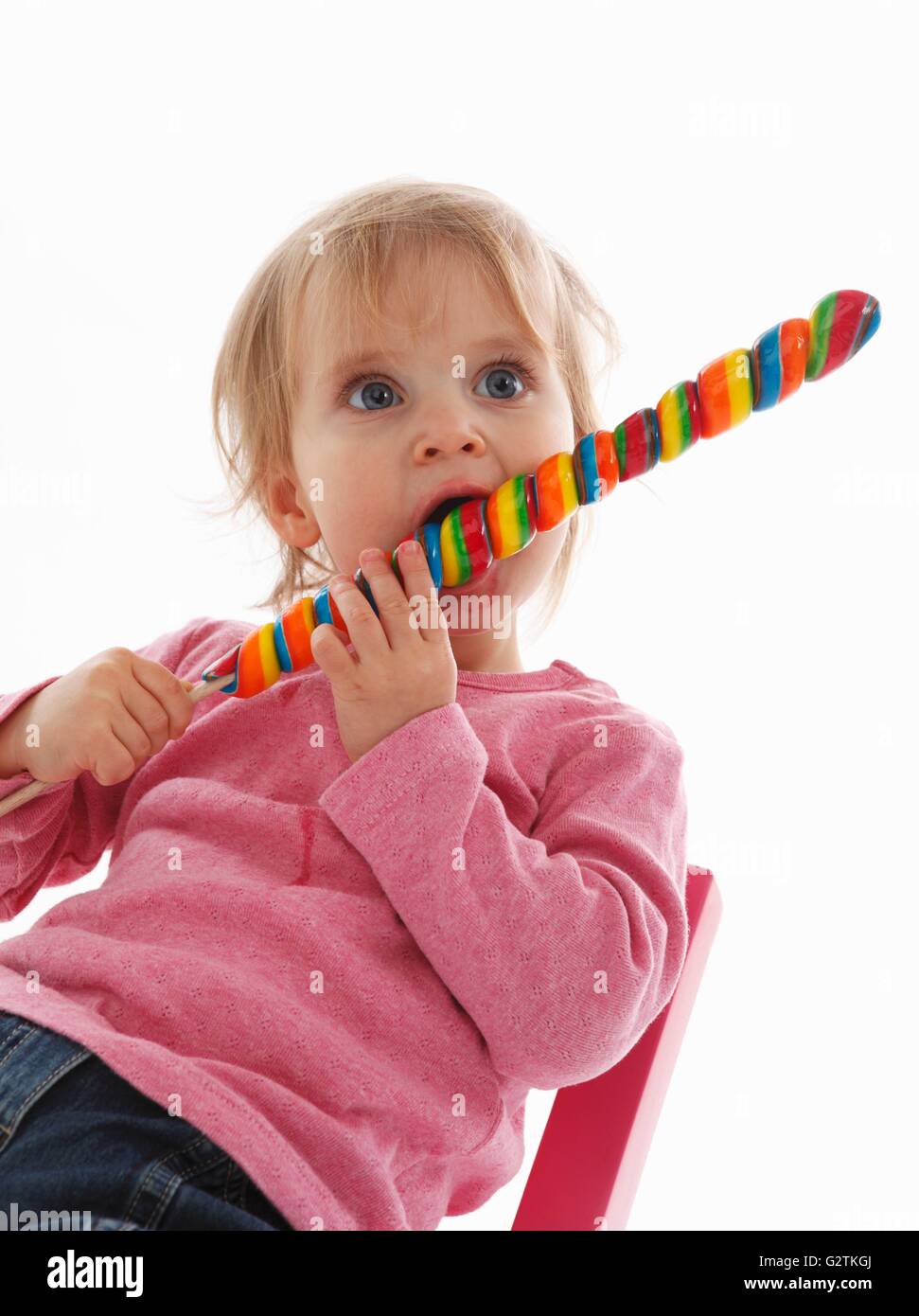 A small child eating a giant lolly Stock Photo - Alamy
