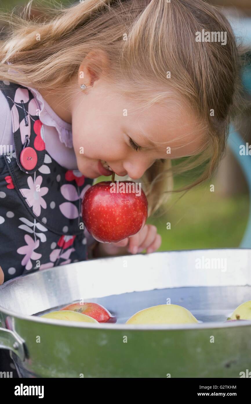 A girl bobbing for apples Stock Photo - Alamy