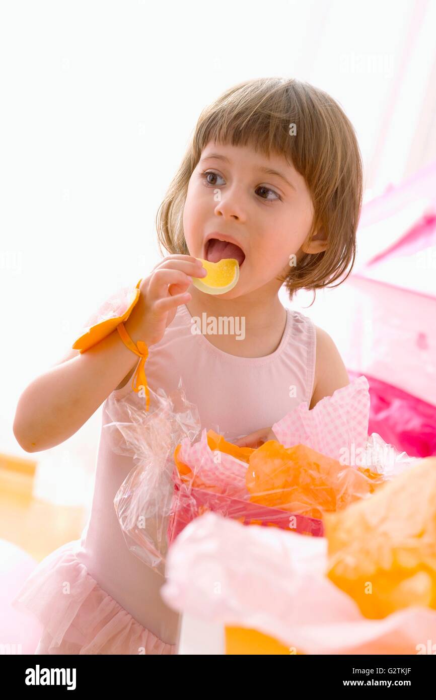 Little girl eating sweets Stock Photo - Alamy
