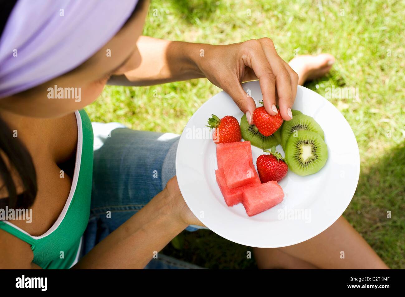 Young woman with plate of fruit Stock Photo - Alamy