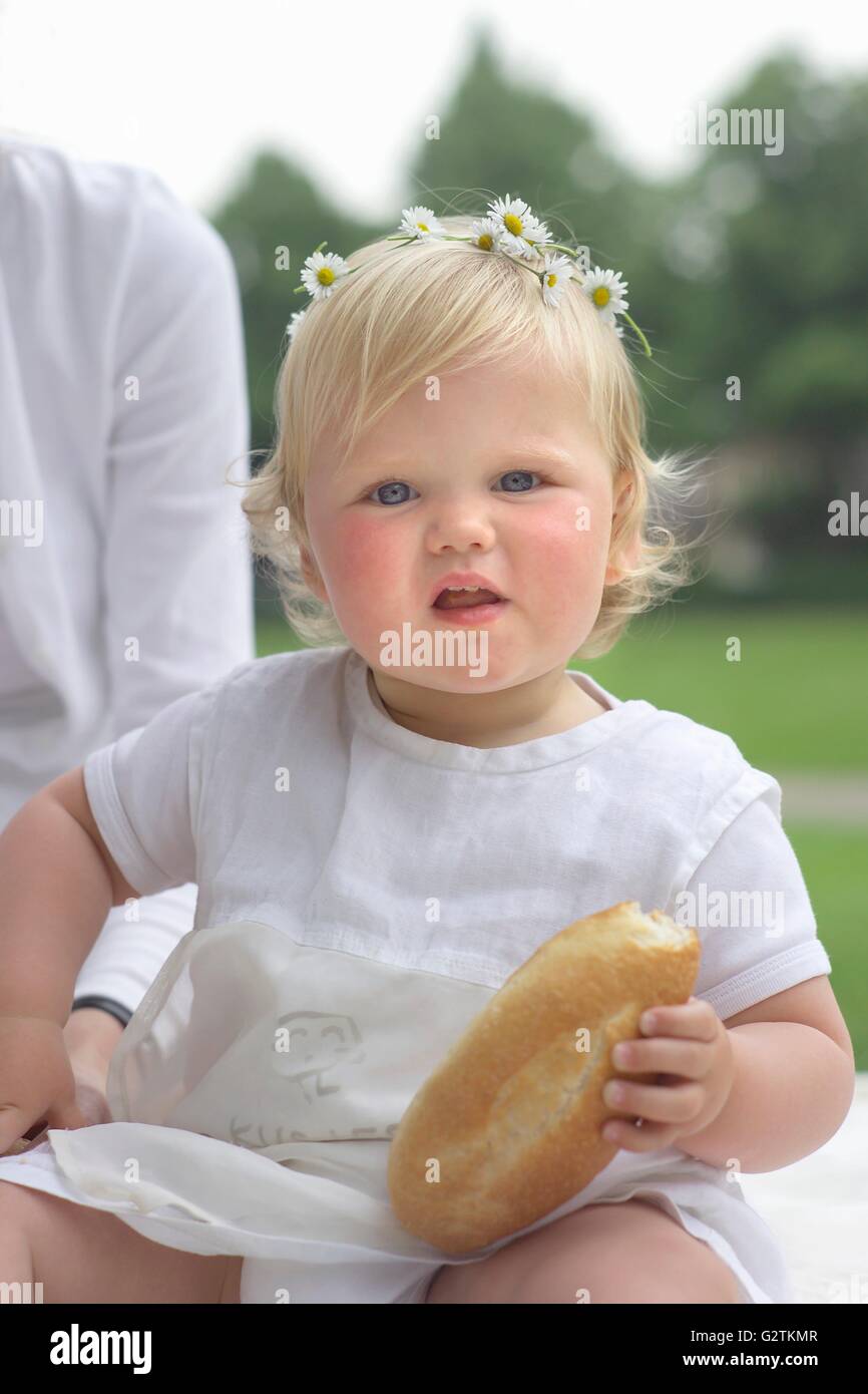 Small girl with bread roll in her hand Stock Photo - Alamy